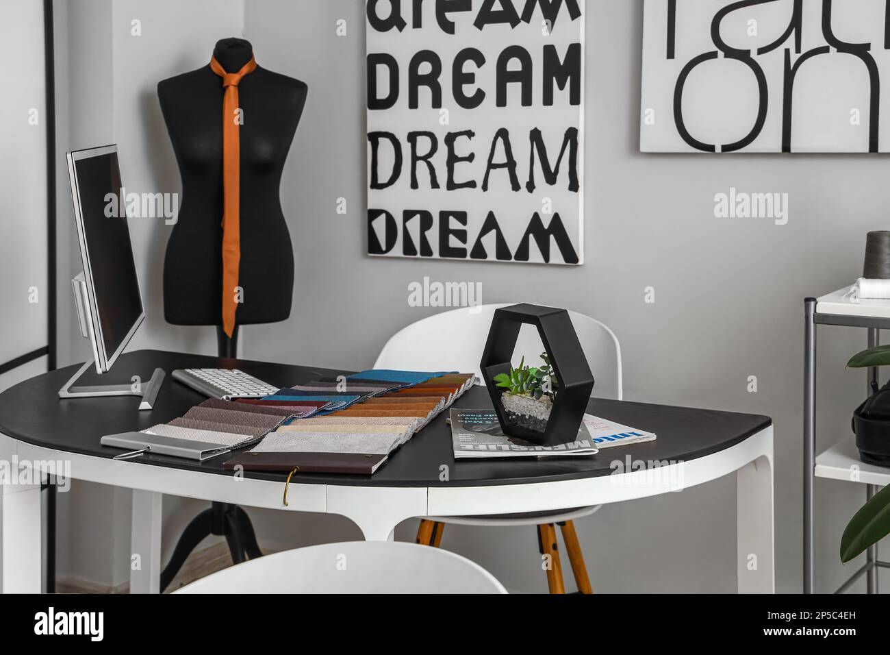 Interior of modern atelier with tailor's workplace and mannequin Stock Photo - Alamy