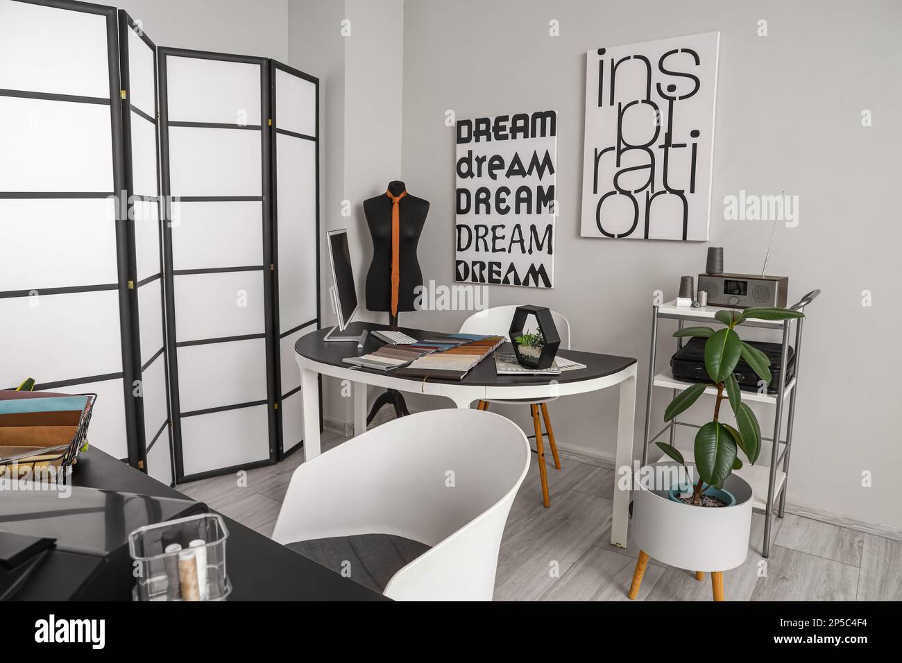 Interior of modern atelier with tables and mannequin Stock Photo - Alamy