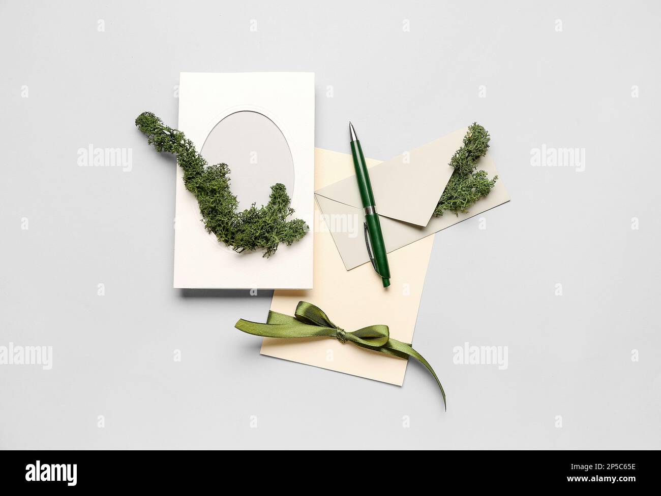 Composition with cards, envelope, pen and moss on white background ...