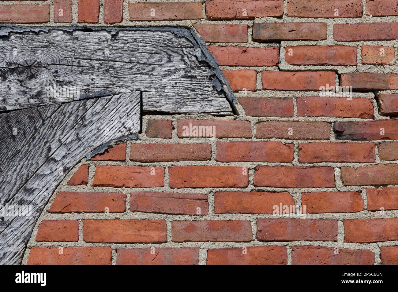 Close up of old, red brick wall that has uneven, horizontal lines and ...