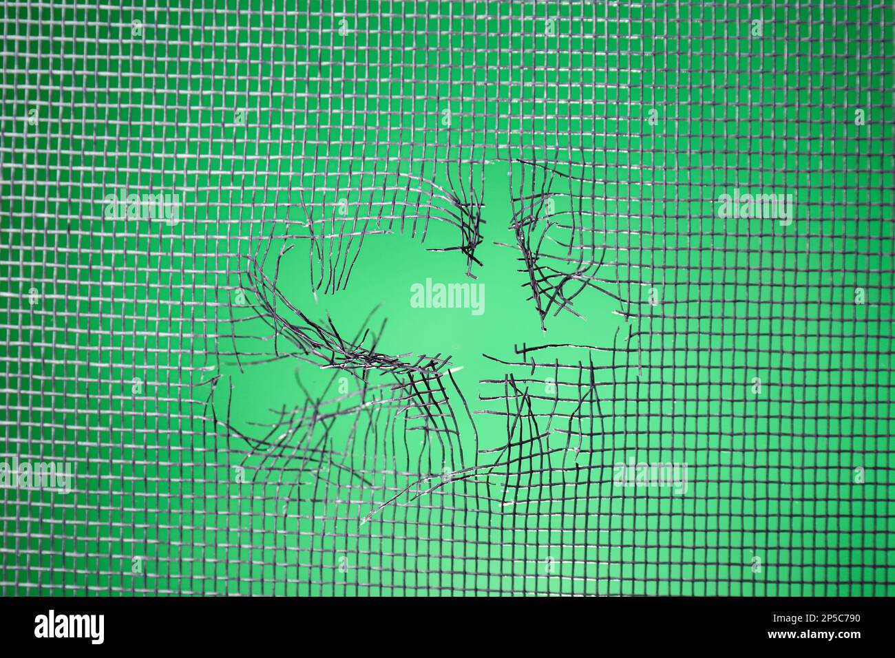 Torn window screen against green background, closeup Stock Photo - Alamy