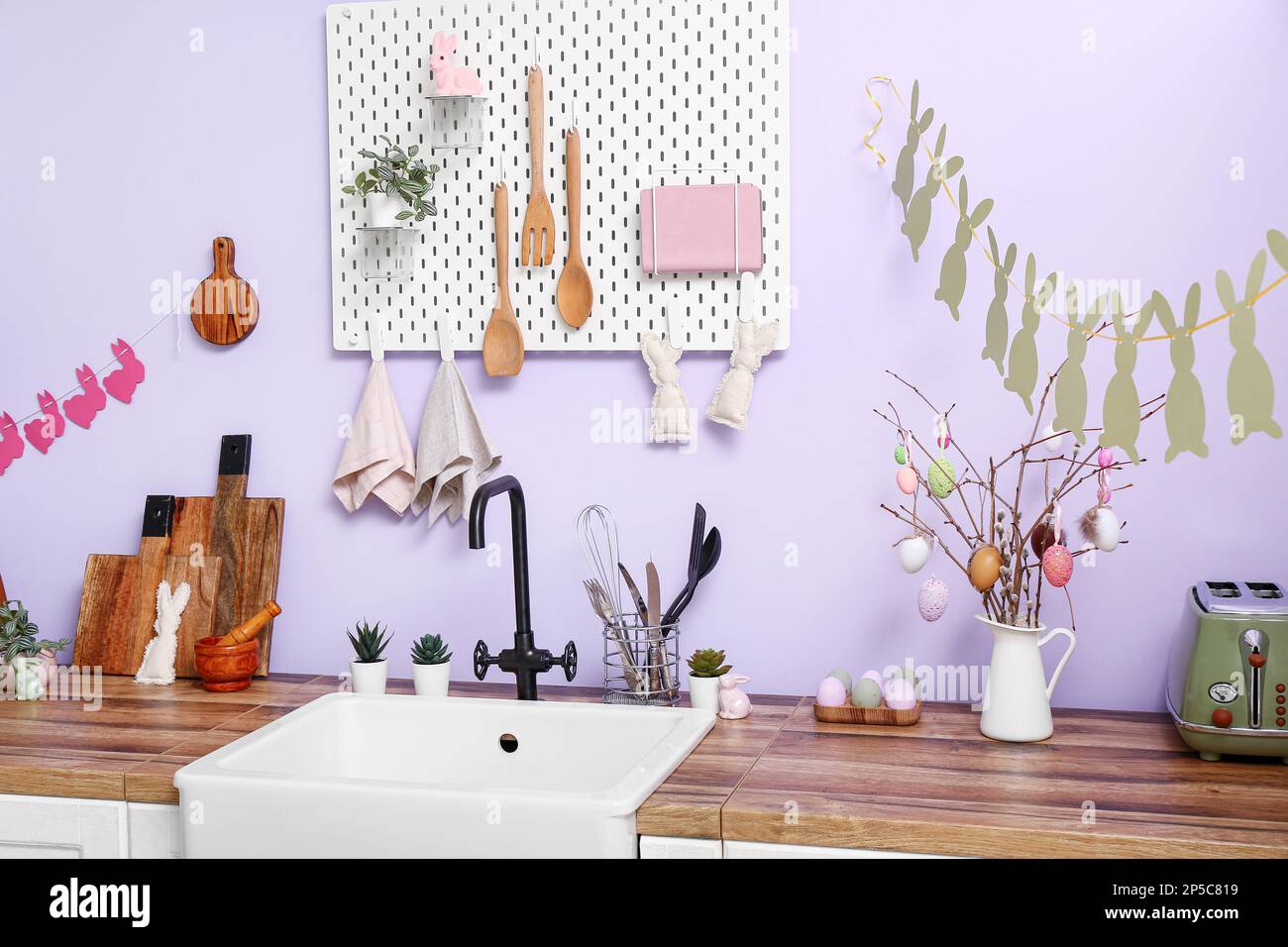 Pegboard with Easter bunnies and vase of willow branches on kitchen ...