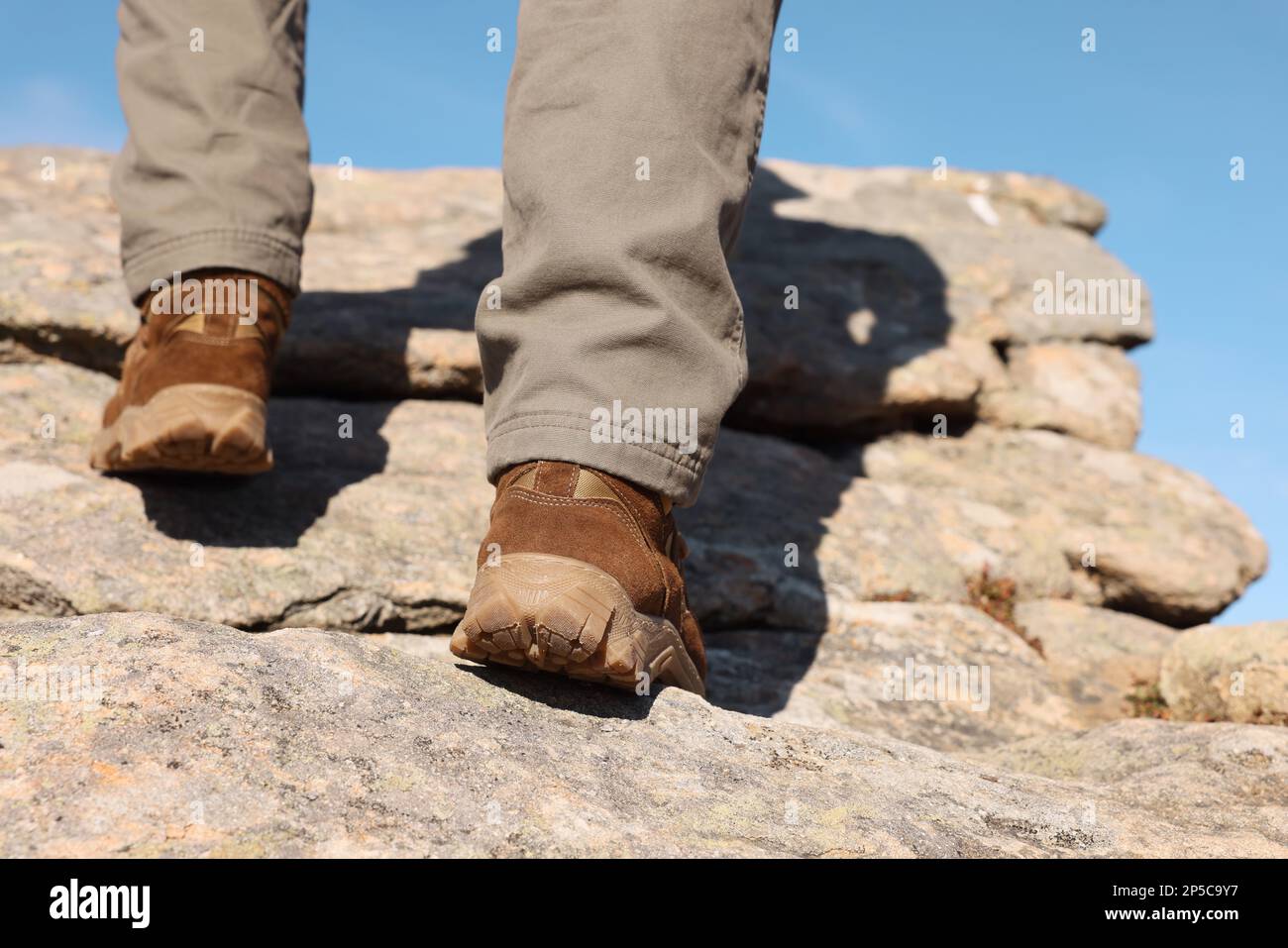 Tourist climbing on cliff, closeup of legs Stock Photo - Alamy