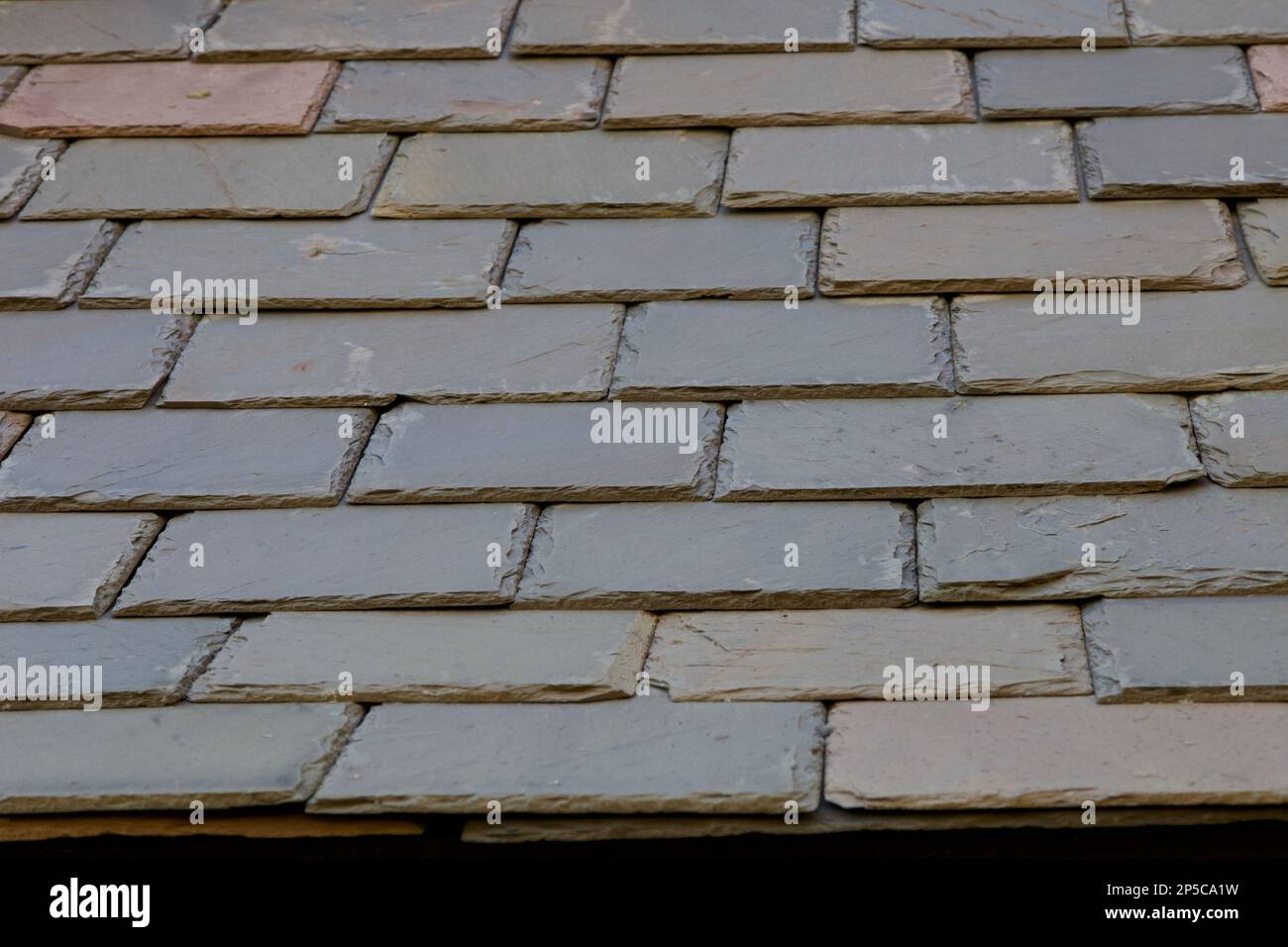 Slate siding tiles on the wall of a building in New England. There is a ...