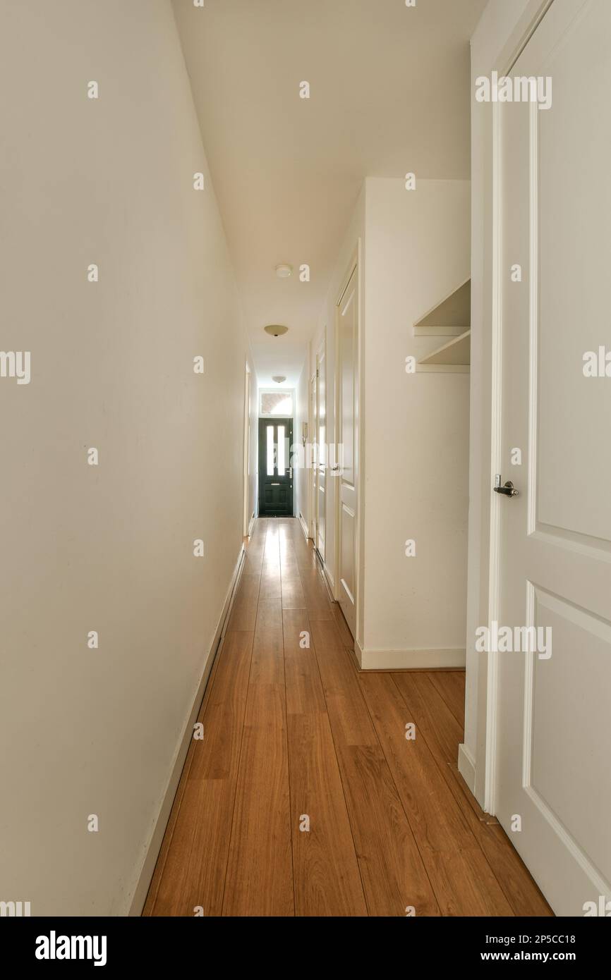 a long hallway with wood floors and white walls in an apartment ...