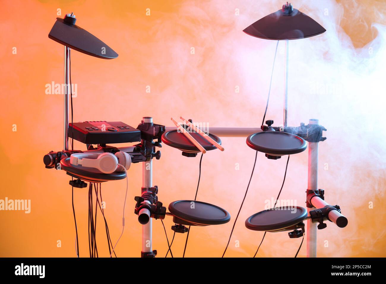 Modern electronic drum kit and smoke on orange background. Musical ...