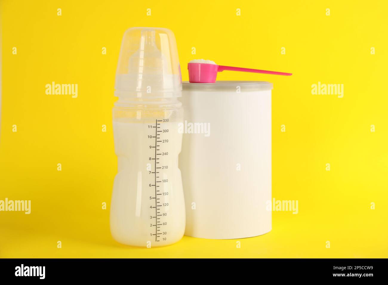 Blank can of powdered infant formula with feeding bottle and scoop on ...