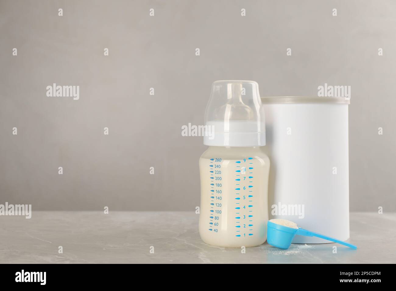 Blank can of powdered infant formula with feeding bottle and scoop on ...