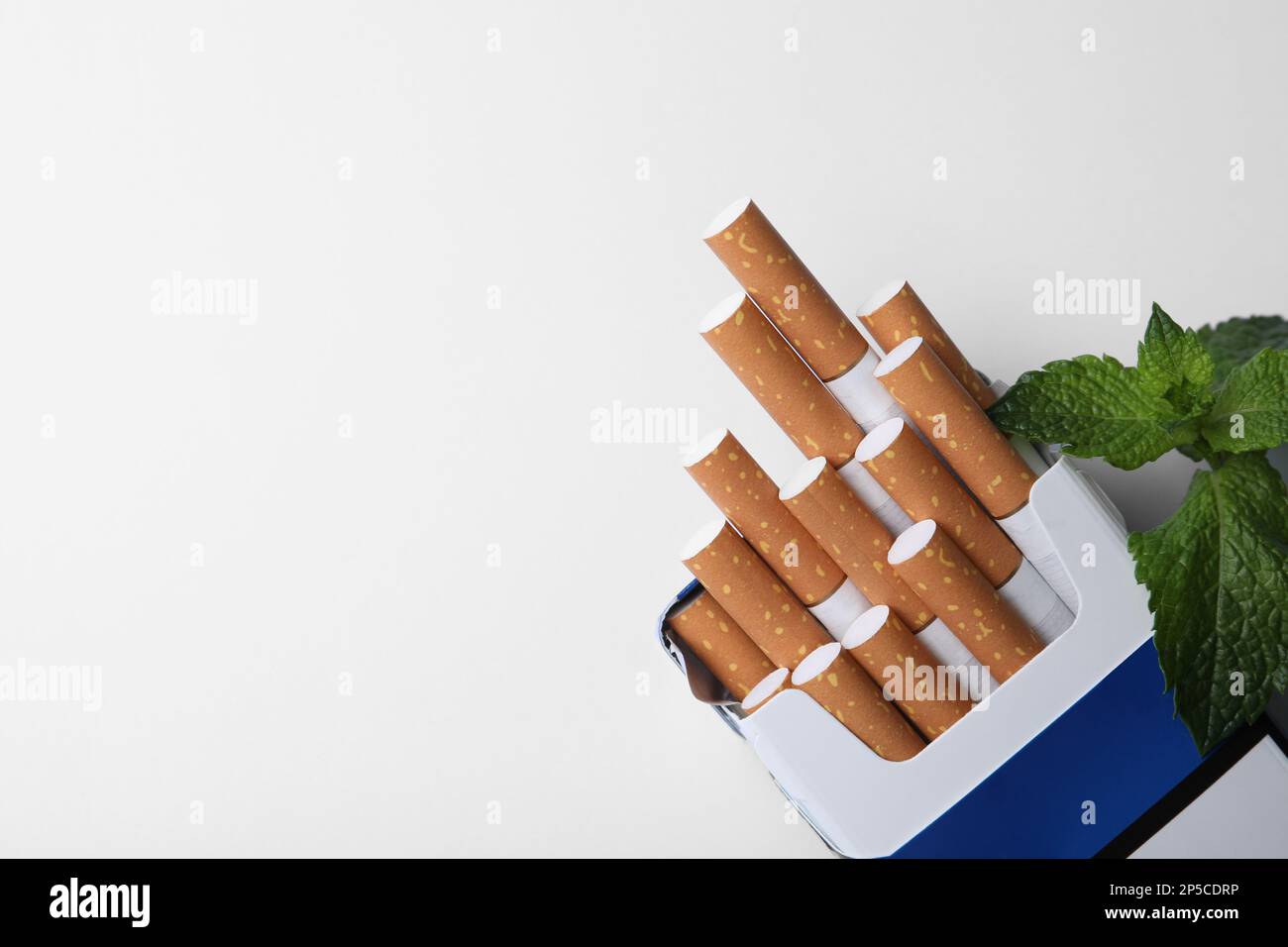 Pack of menthol cigarettes and mint on white background, top view ...