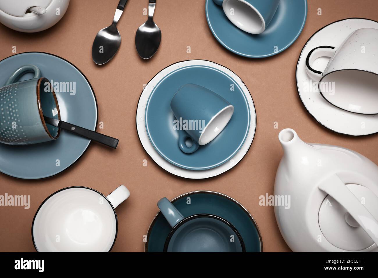 Different cups and teapot on brown background, flat lay Stock Photo - Alamy