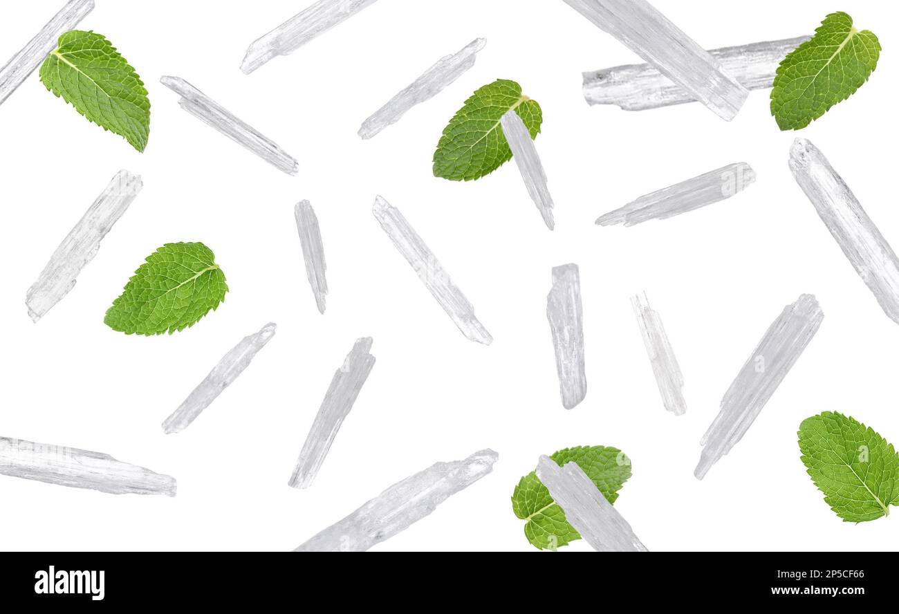 Translucent menthol crystals and green mint leaves falling on white ...