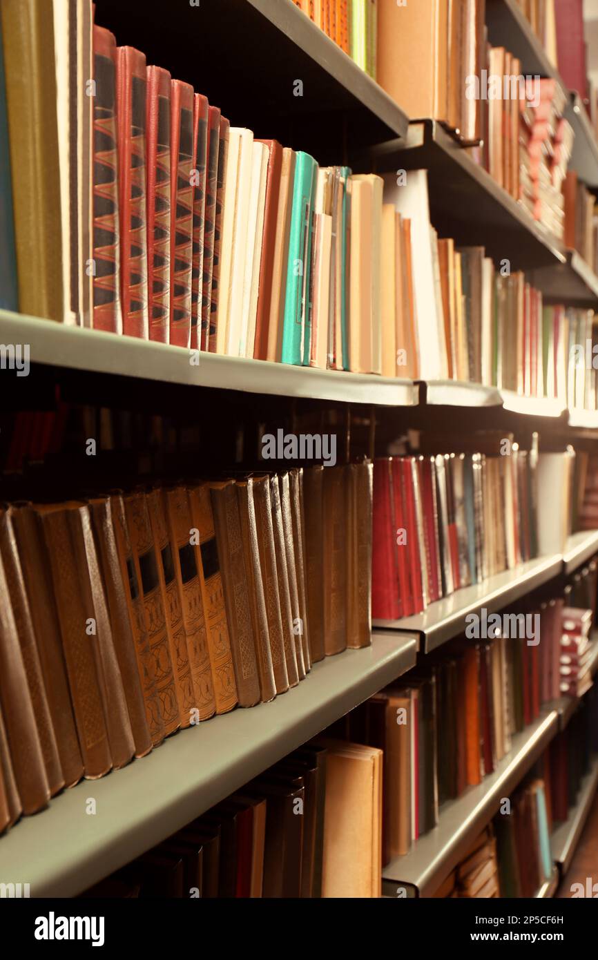 Collection of different books on shelves in library Stock Photo - Alamy