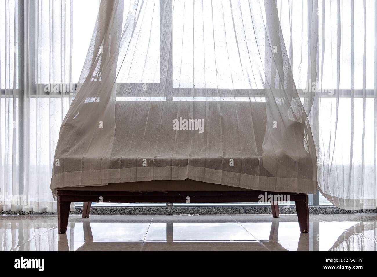 The wind from the window blow the curtains onto the sofa Stock Photo ...