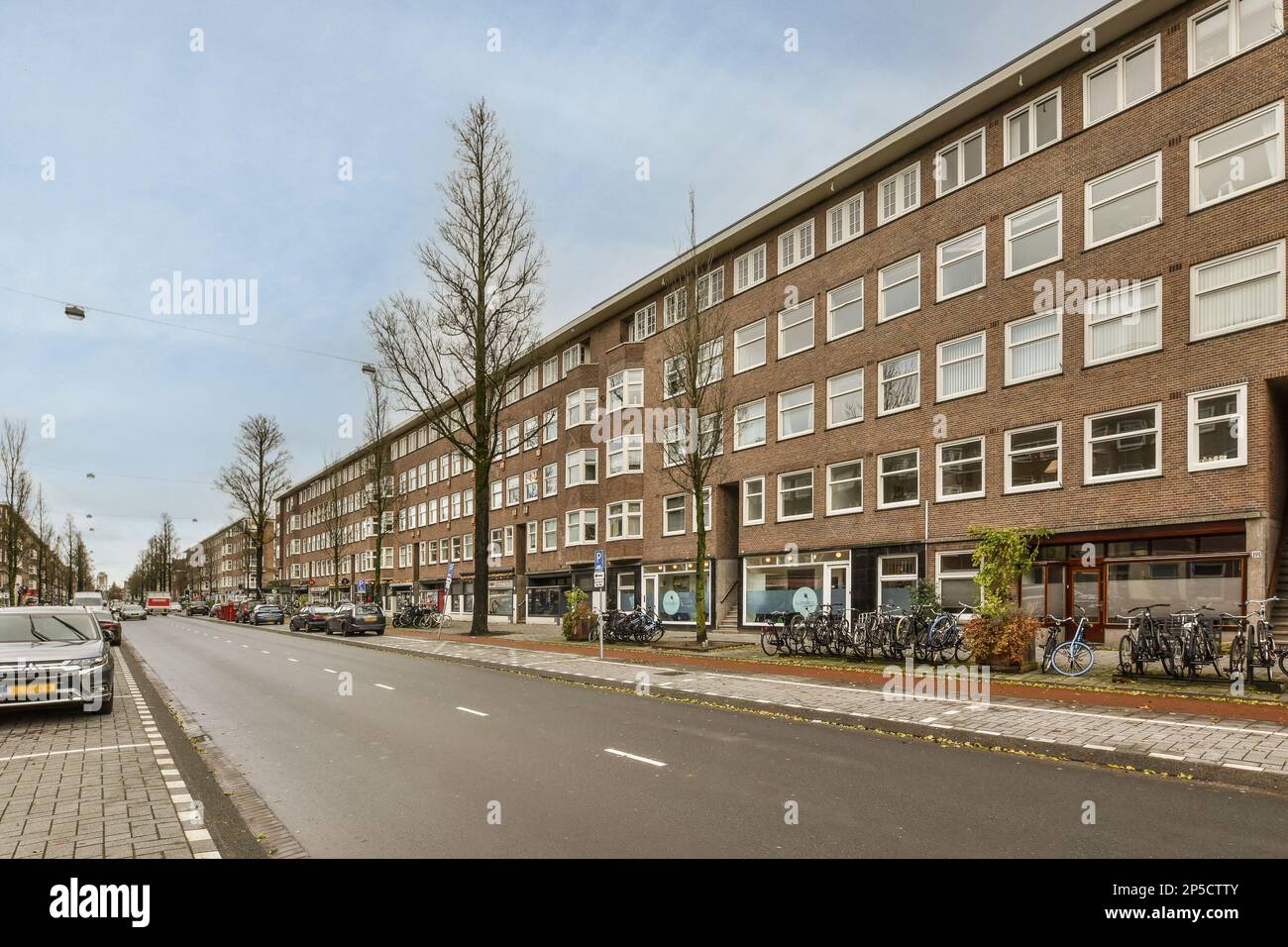 a city street with cars parked on the side and buildings in the middle ...