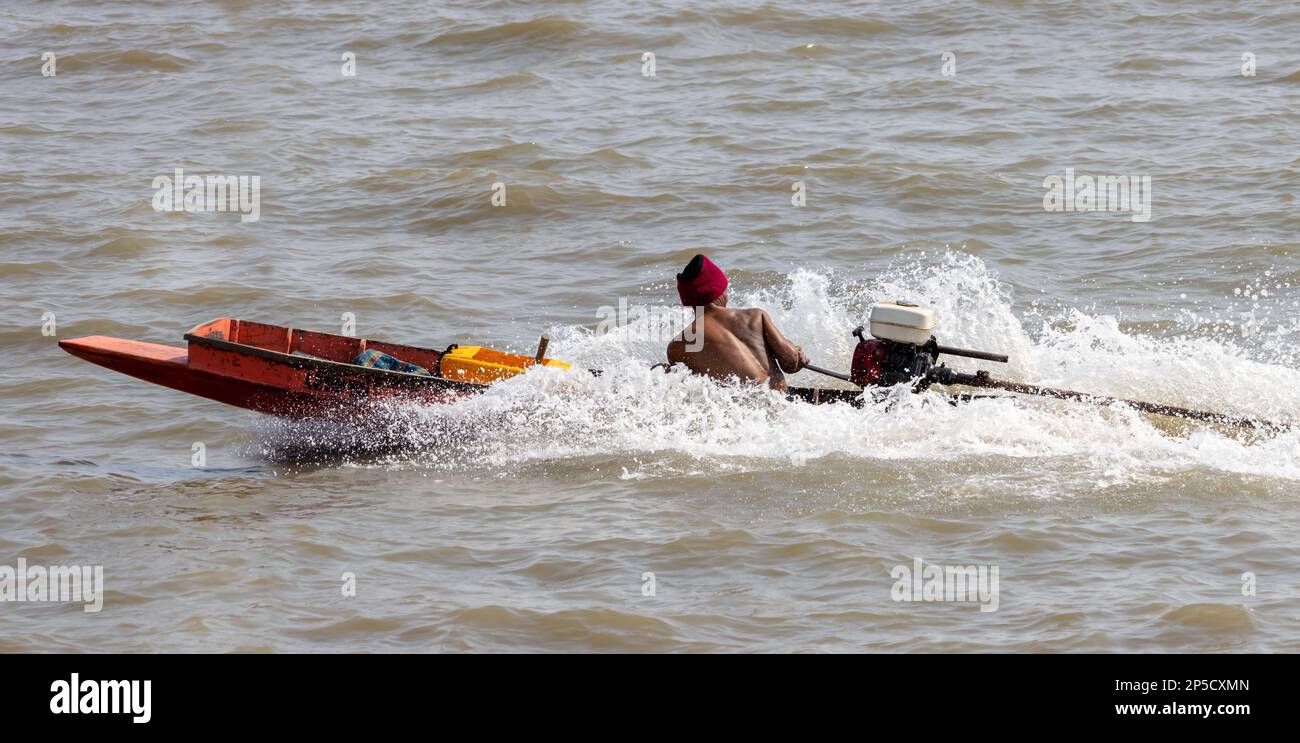 A thai man drives a fast boat with typical "long tail" at the sea Stock ...