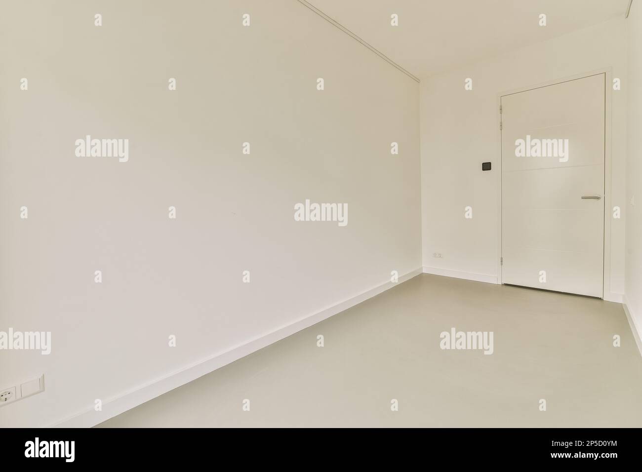 an empty room with white walls and floor to the right, there is a door ...
