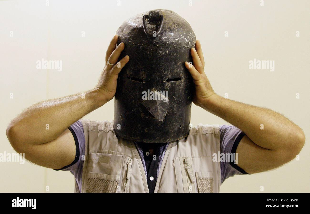 An Iraqi man wears a metal mask used as a torture device by the regime ...