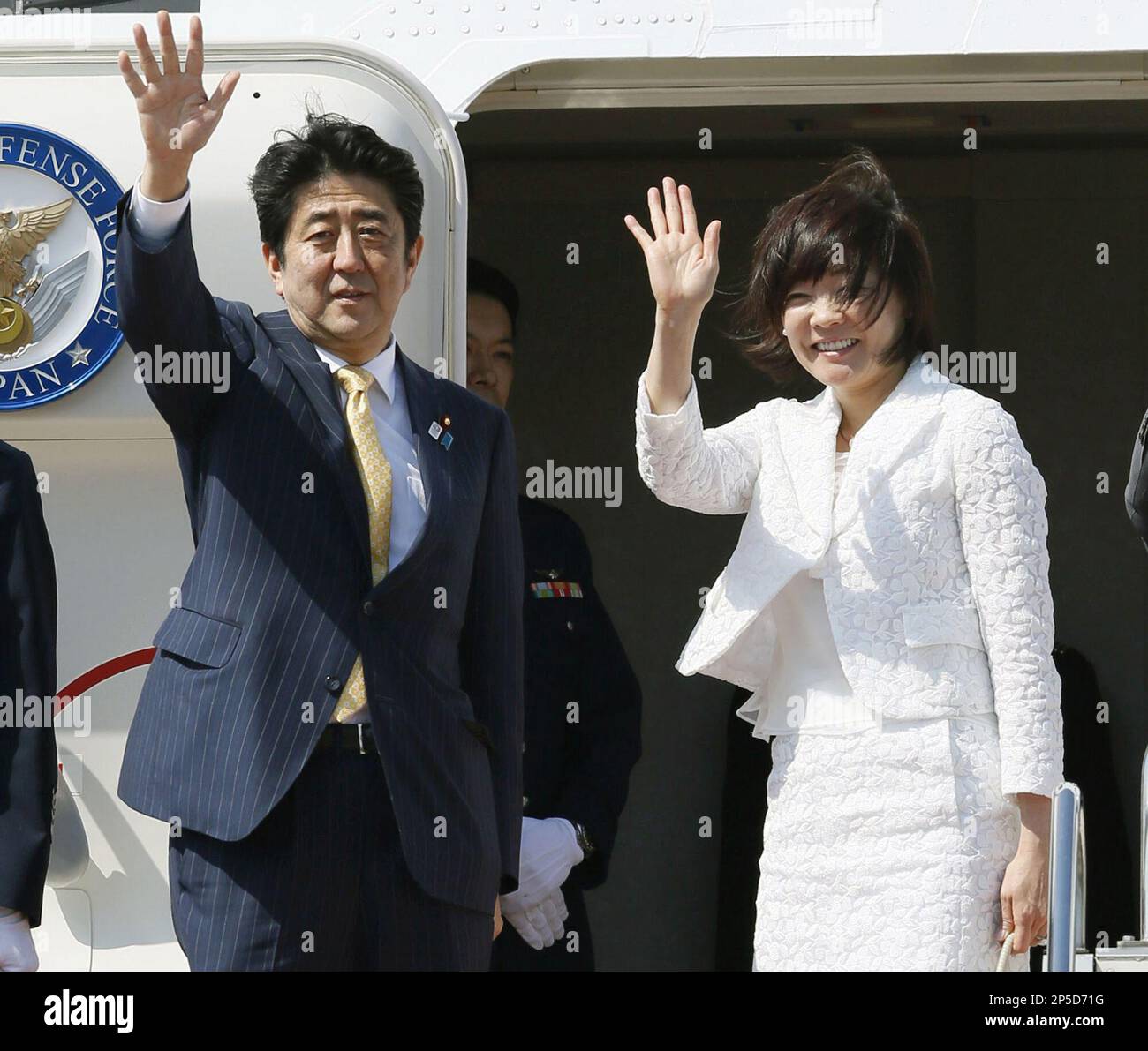 Japanese Prime Minister Shinzo Abe and his wife Akie wave before boarding a plane at Tokyo's ...