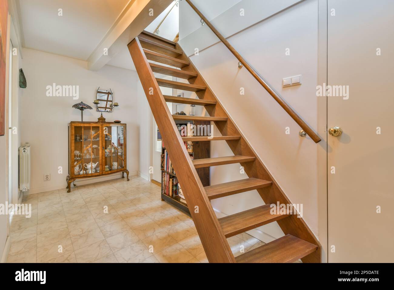 a stairway way in a house with white walls and beige tile flooring the ...