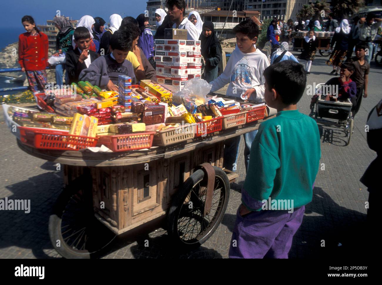Child vendor in Beirut selling sweets and smallgoods on a mobile stall ...