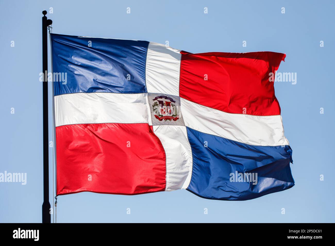 Dominican Republic flag waving against clear blue sky, close up ...