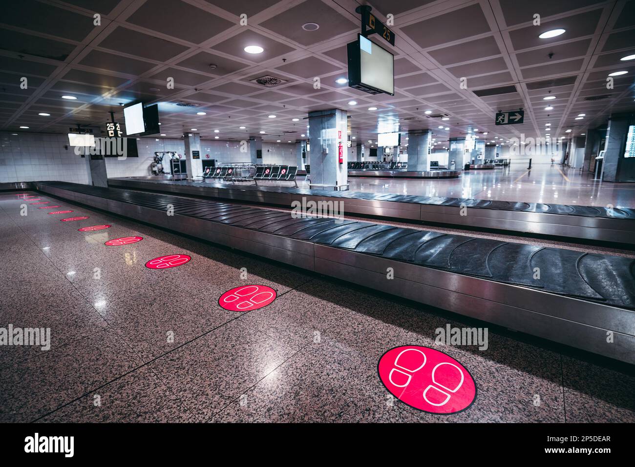 A clear baggage claim area in the Lisbon airport, low-key. On the floor ...