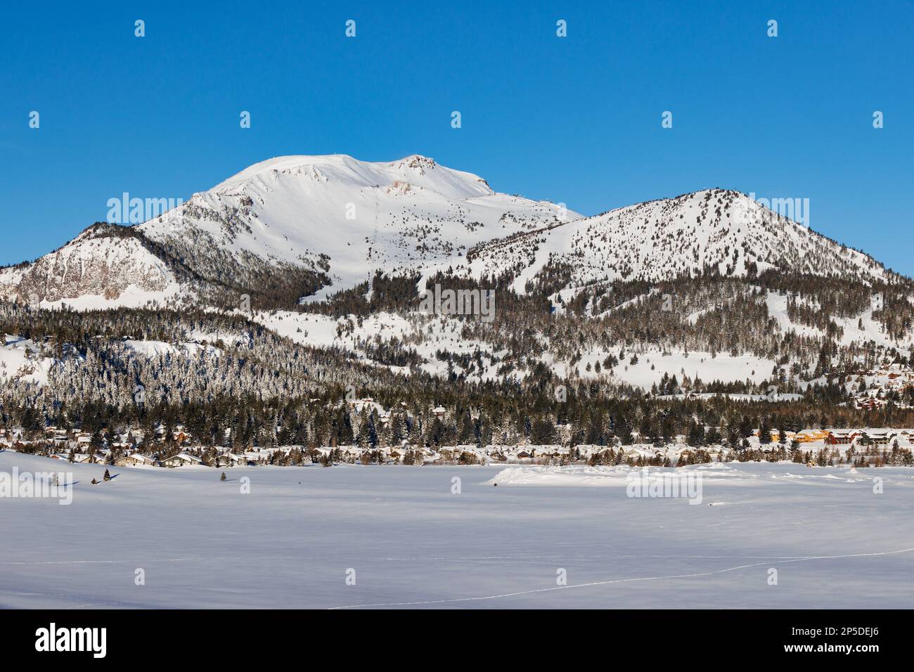 A view of snow-covered Mammoth Mountain ski resort with blue skies ...