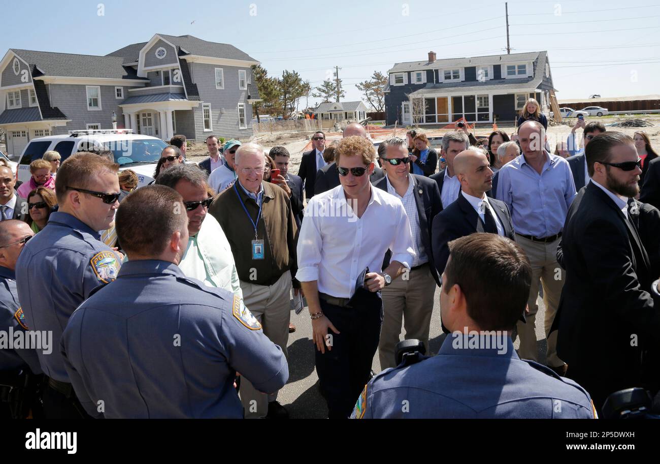 Britain's Prince Harry, center, talks to people during a visit an area ...