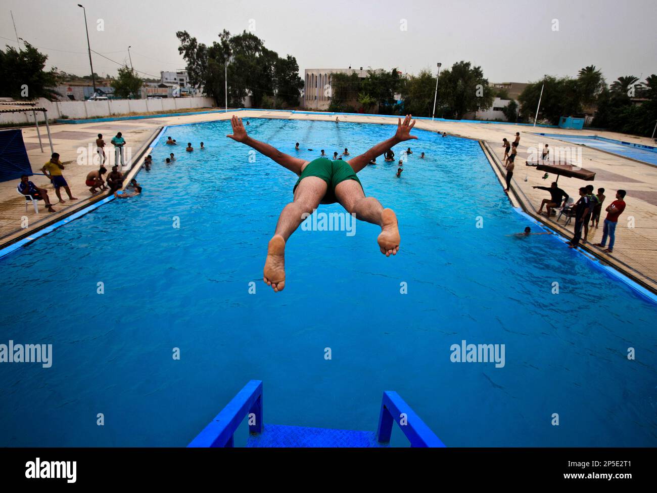 An Iraqi man dives into a public swimming pool in Baghdad, Iraq, Sunday ...