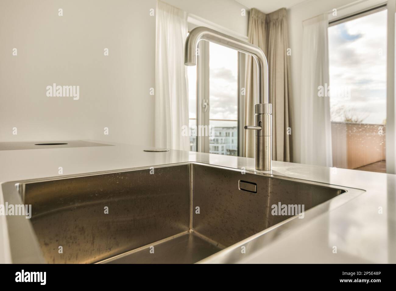 a kitchen sink in front of a window with the view of an outside ...