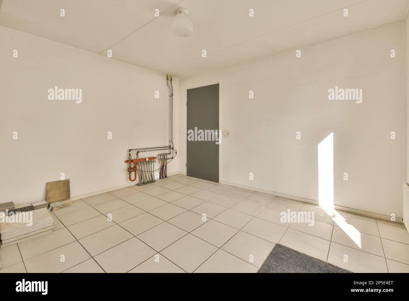 an empty room with white walls and tile flooring in the middle, there ...