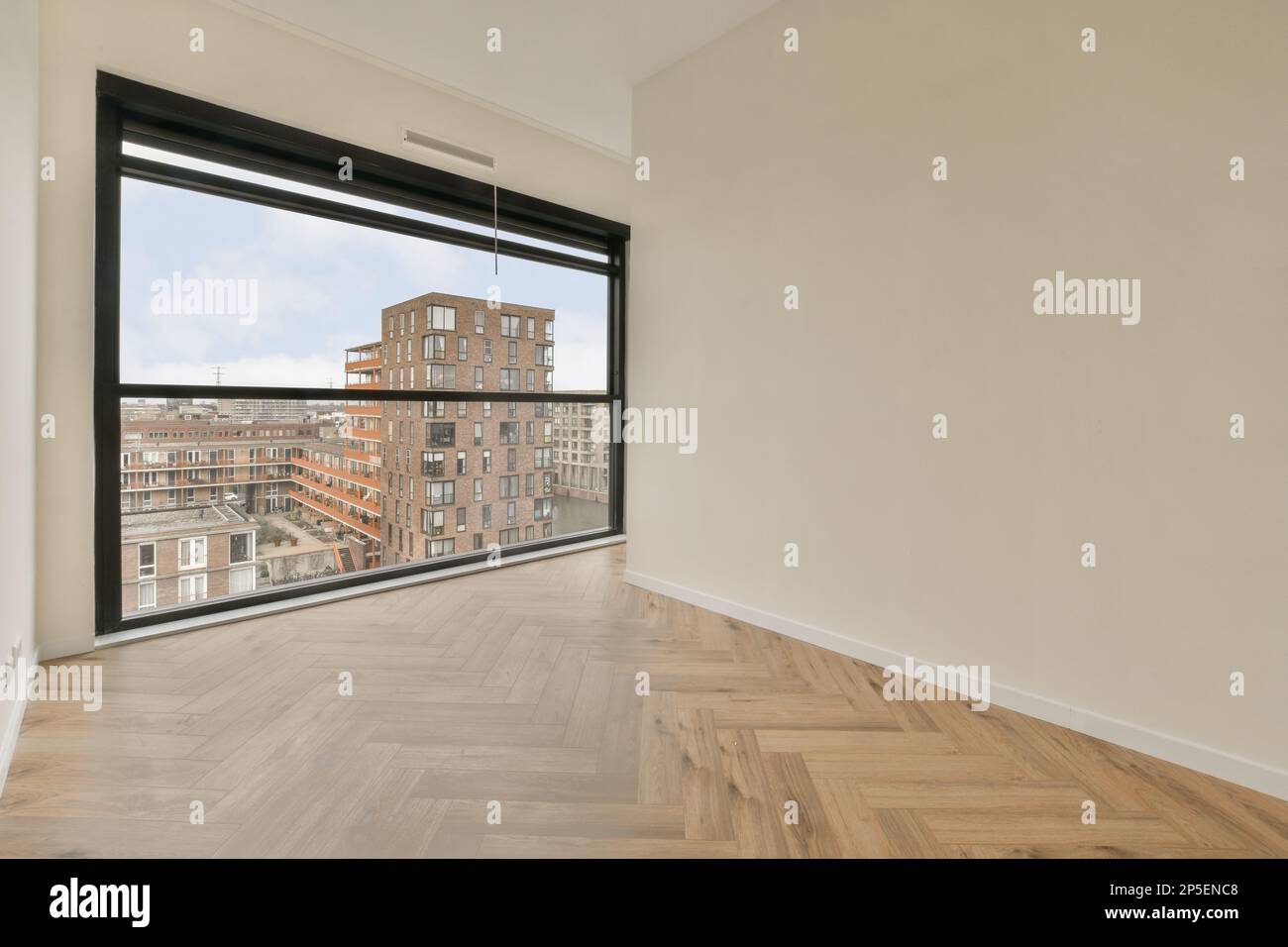 an empty room with wood flooring and large windows looking out onto the ...