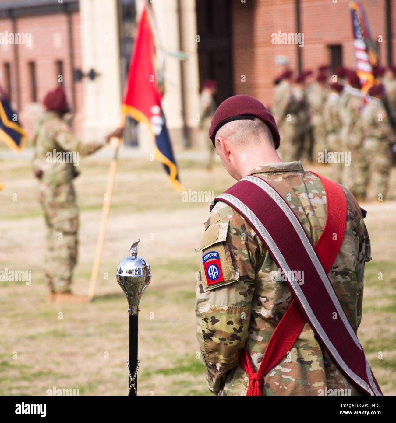Master musician, Fort Bragg, with head lowered next to ceremonial staff ...