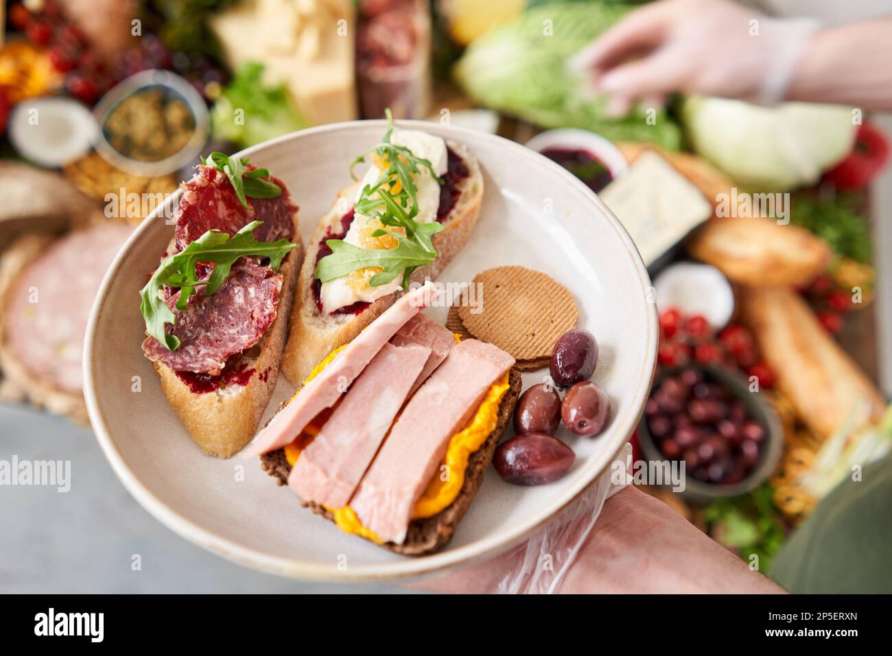 The waiter makes bruschetta or tapas. Table full of mediterranean ...