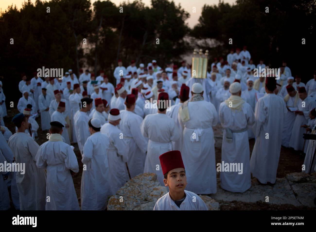 A Samaritan boy looks outward as a Priest of the ancient Samaritan ...