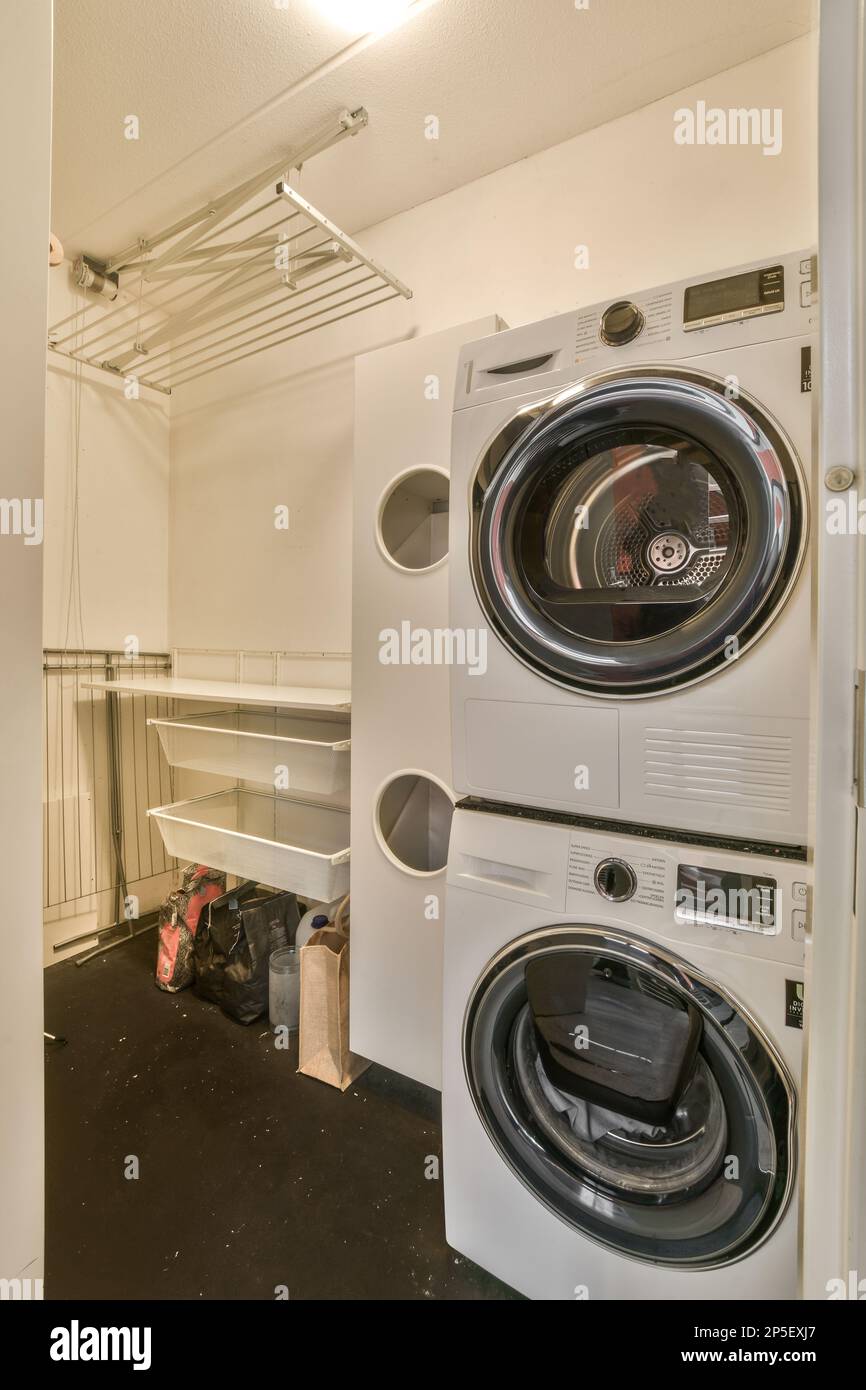 a laundry room with two washers and a dryer on the floor, in front of ...