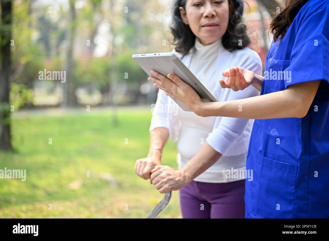 Cropped image of an Asian female nurse or caregiver is talking and ...