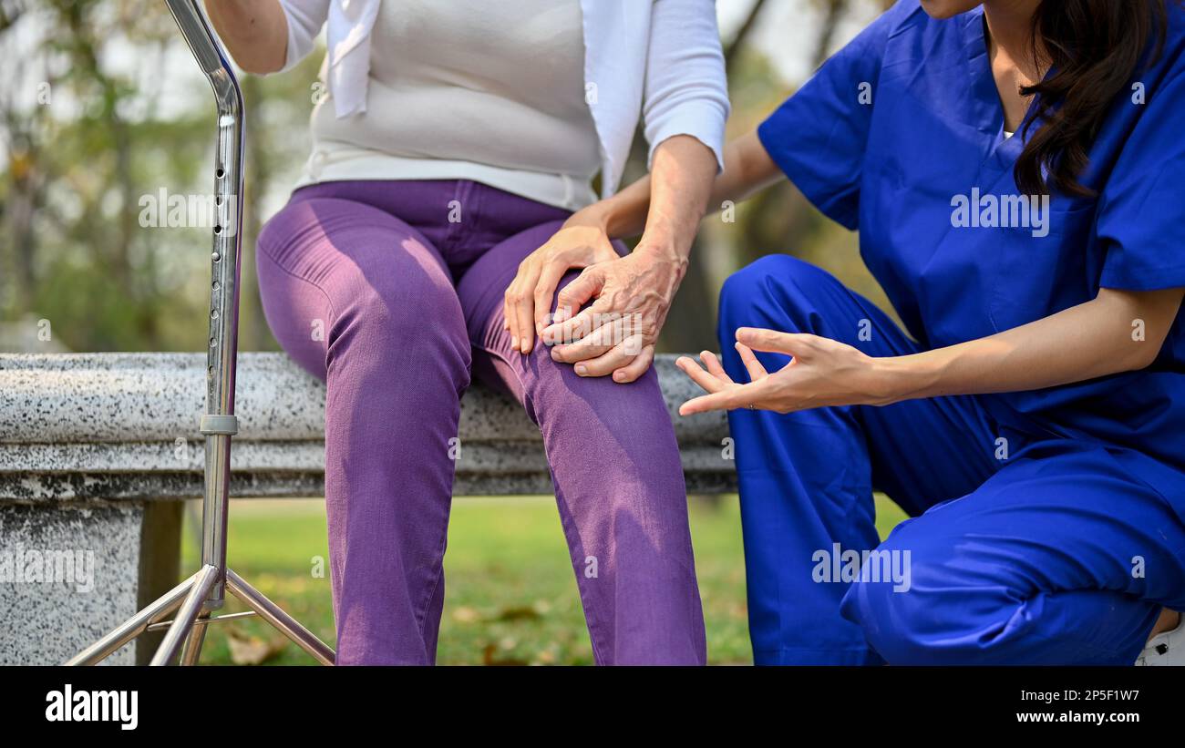 Cropped image of caring caregiver or nurse helping and massaging an old ...