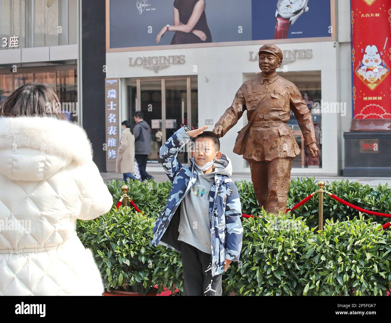 People take photos in front of the bronze statue of Lei Feng, a Chinese ...