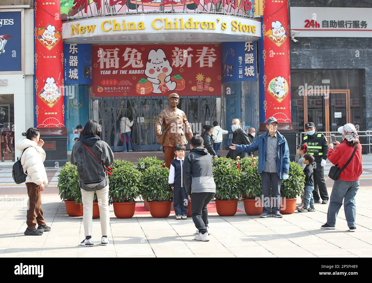 People take photos in front of the bronze statue of Lei Feng, a Chinese ...