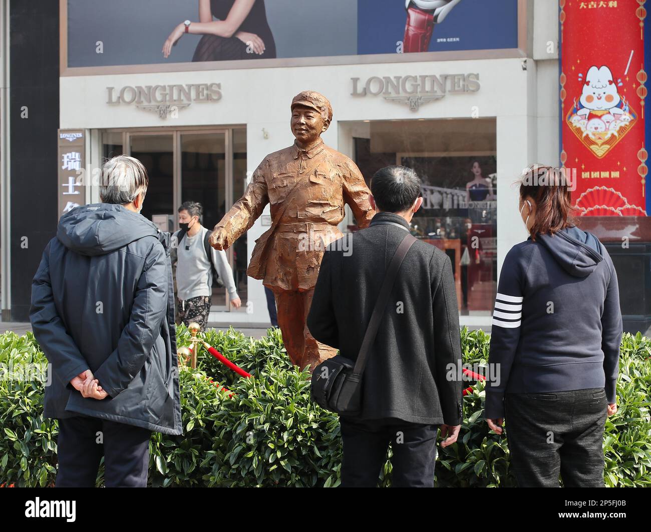 People take photos in front of the bronze statue of Lei Feng, a Chinese ...