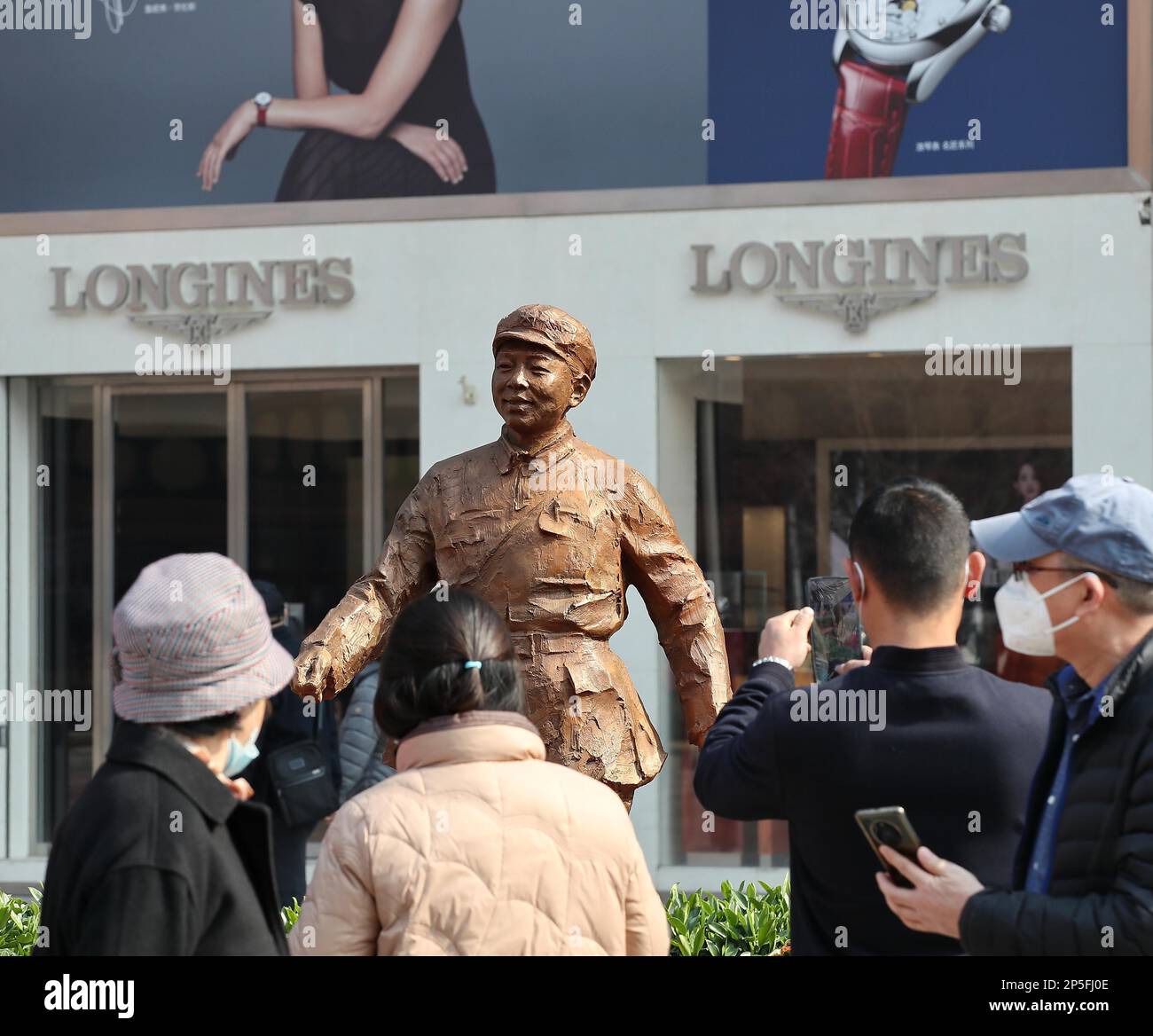 People take photos in front of the bronze statue of Lei Feng, a Chinese ...