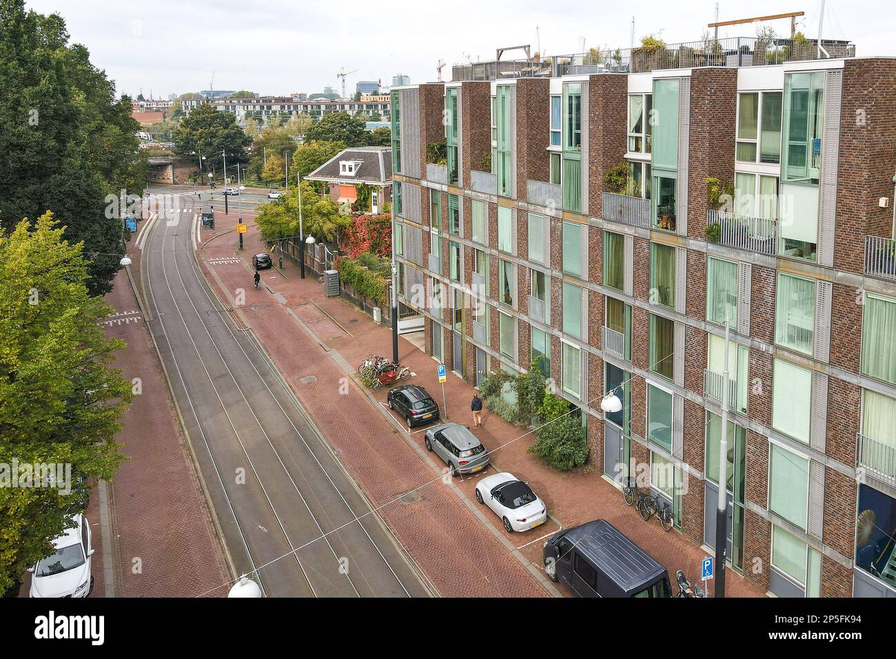 a city street with cars parked on the side of the road and buildings in ...