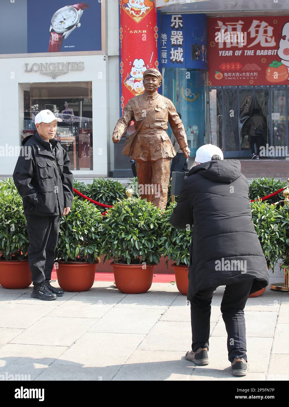 People take photos in front of the bronze statue of Lei Feng, a Chinese ...