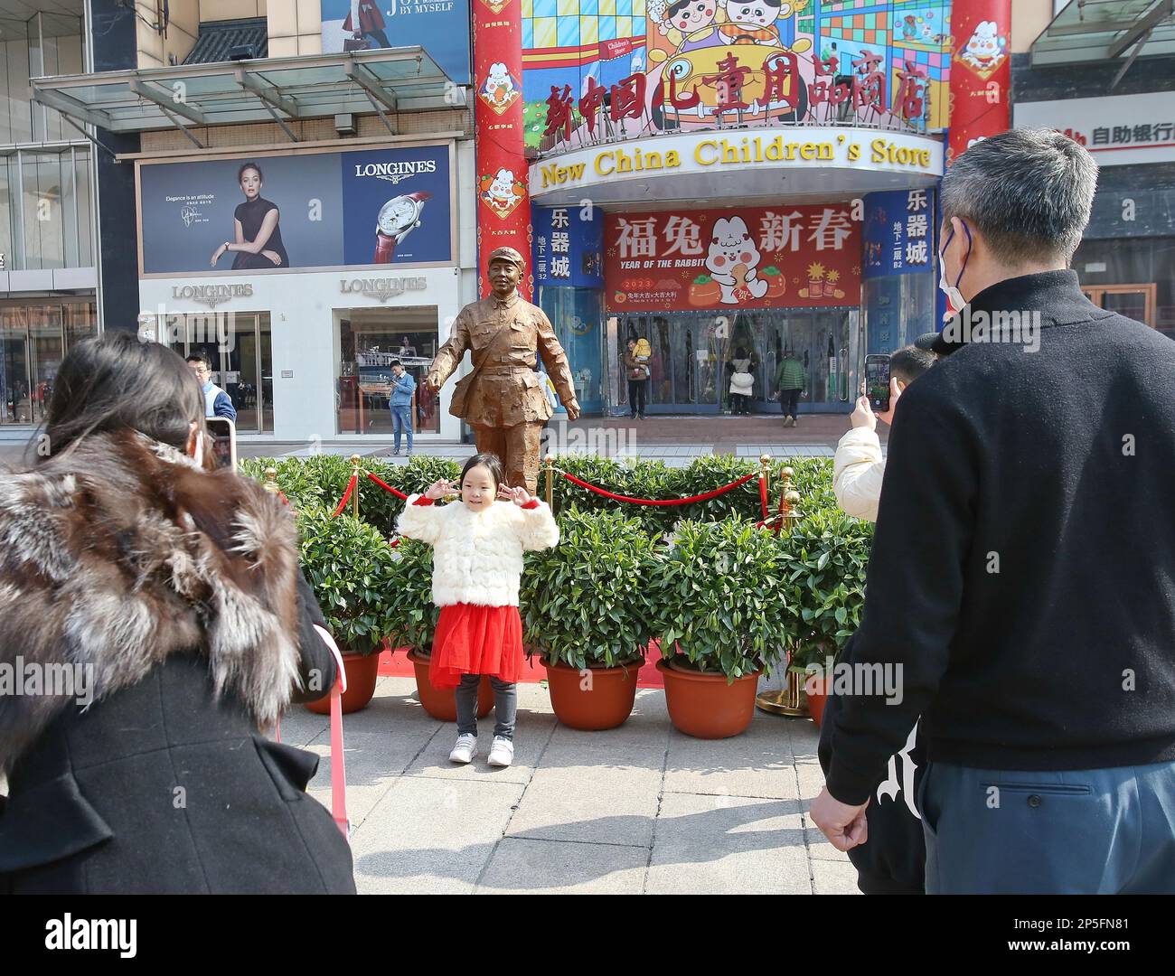 People take photos in front of the bronze statue of Lei Feng, a Chinese ...