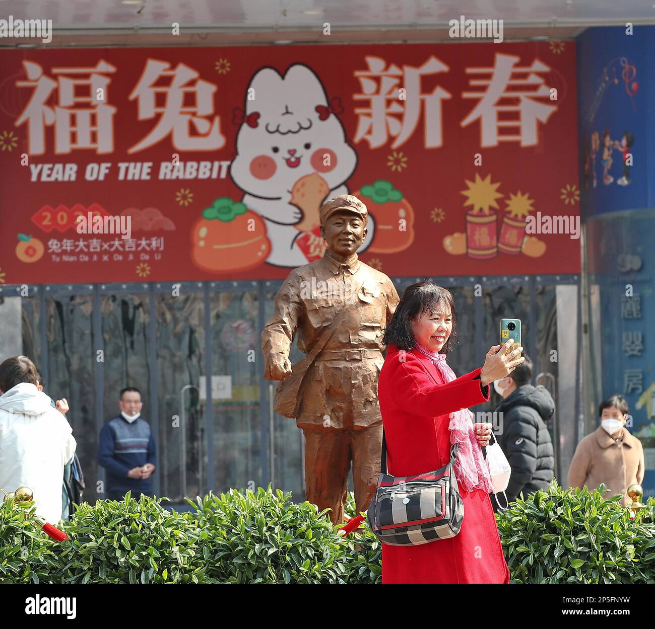 People take photos in front of the bronze statue of Lei Feng, a Chinese ...