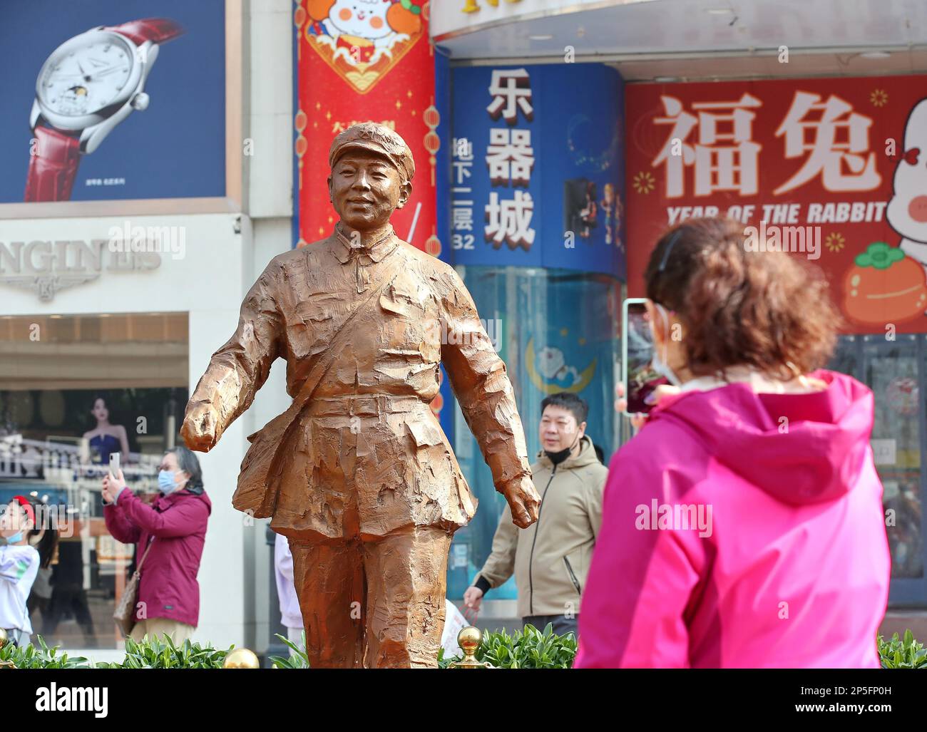 People take photos in front of the bronze statue of Lei Feng, a Chinese ...