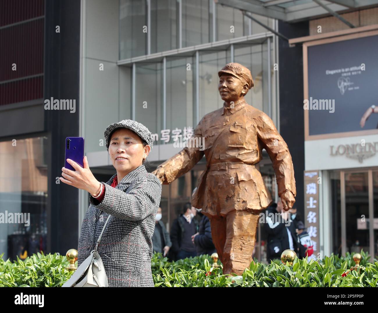 People take photos in front of the bronze statue of Lei Feng, a Chinese ...