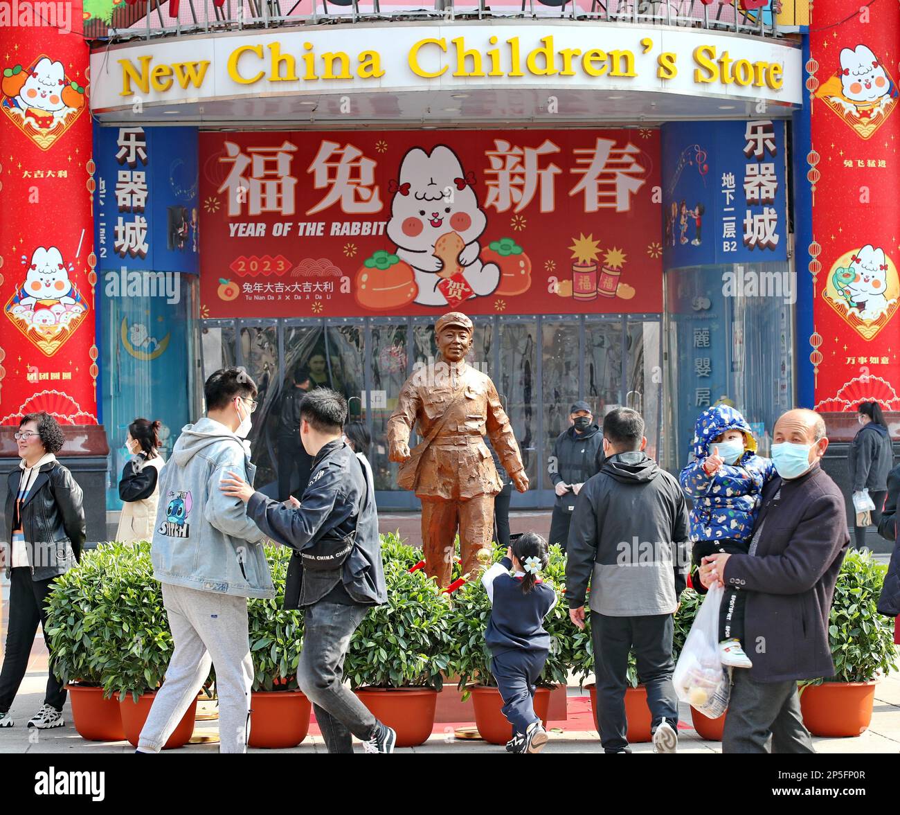 People take photos in front of the bronze statue of Lei Feng, a Chinese ...