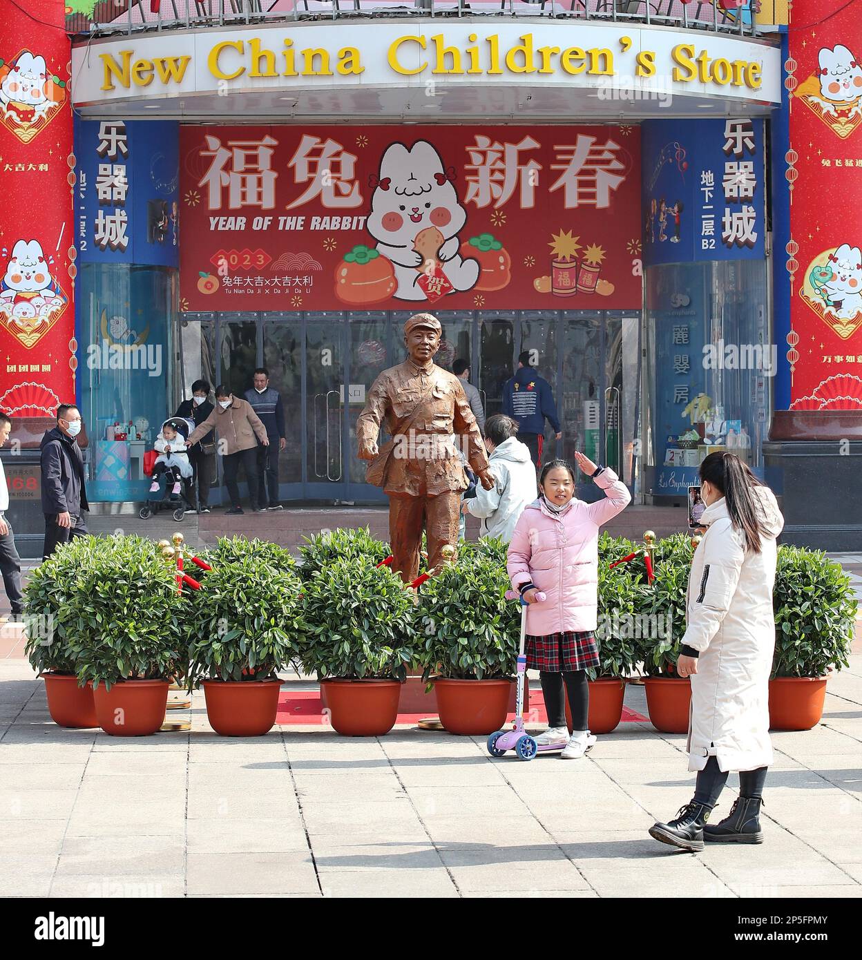 People take photos in front of the bronze statue of Lei Feng, a Chinese ...